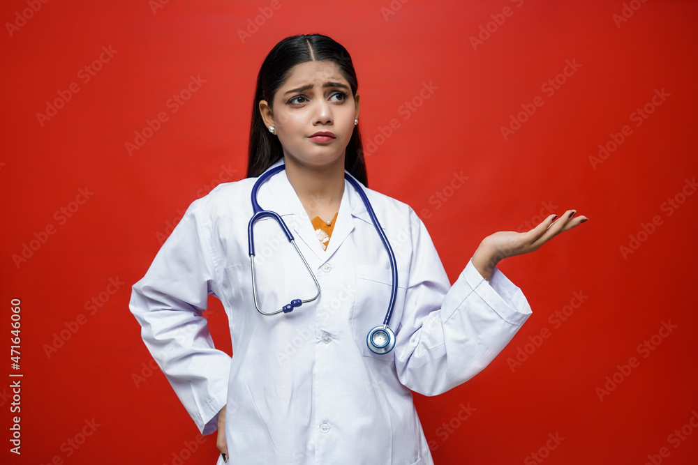 confused young female doctor wearing coat and stethoscope around neck ...