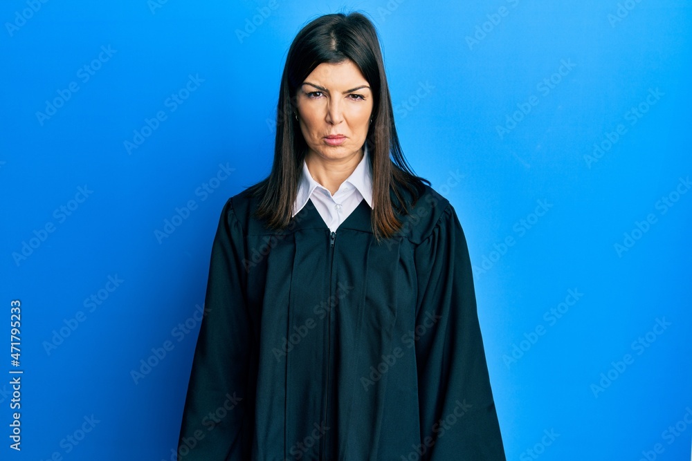 Young hispanic woman wearing judge uniform depressed and worry for ...