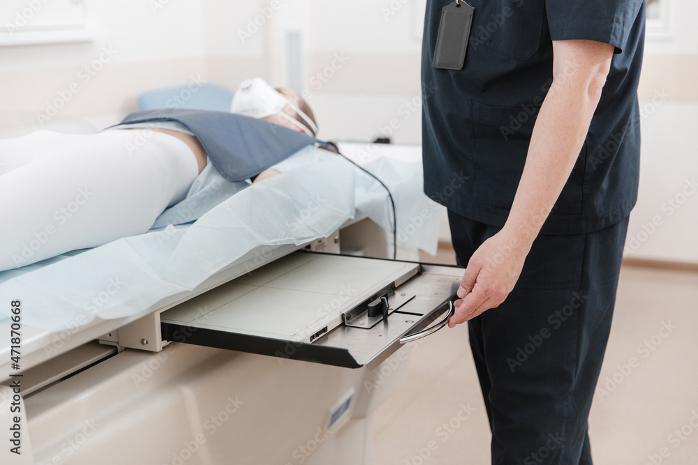 Doctor taking x-ray of patient lying on gurney. Hospital radiology room ...