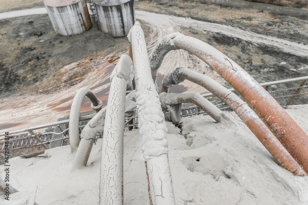 Old system of pipes on the barrel. White fertilizers or sand pipeline ...