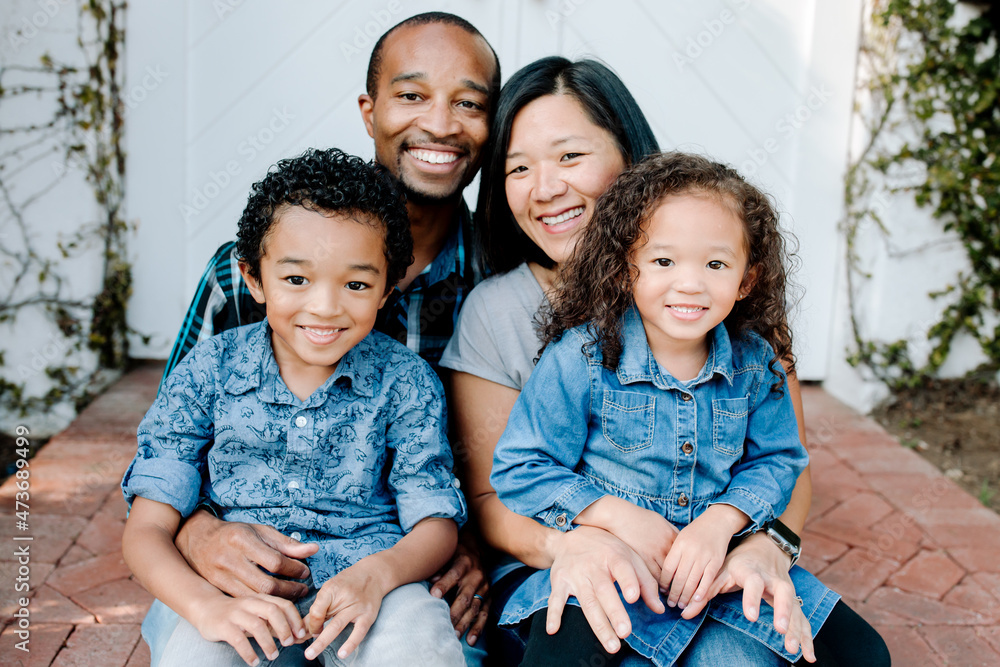 Portrait of happy mixed race family on porch Stock Photo | Adobe Stock