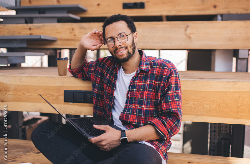 Portrait of Latino IT professional with netbook looking at camera while ...
