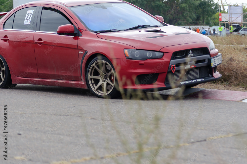 Red sedan drives at high speed on a paved road. Mitsubishi Lance Stock ...