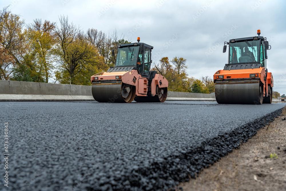 Laying a new asphalt on the road. Construction of the road. Stock Photo ...