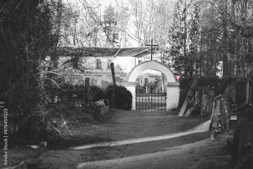 pathway out of cemetery. Cemetery gate with arc and catholic cross ...