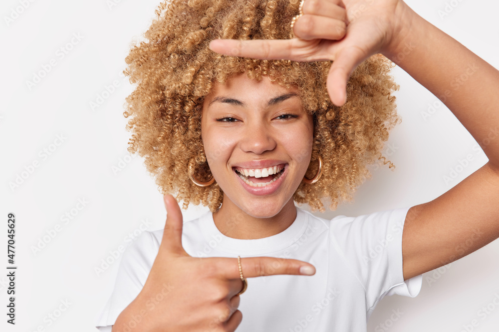 Snap. Positive woman with curly hair takes picture looks through hand ...