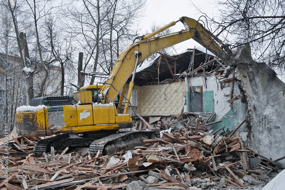 Building demolition. Excavator breaks old two-storey house. Industrial ...