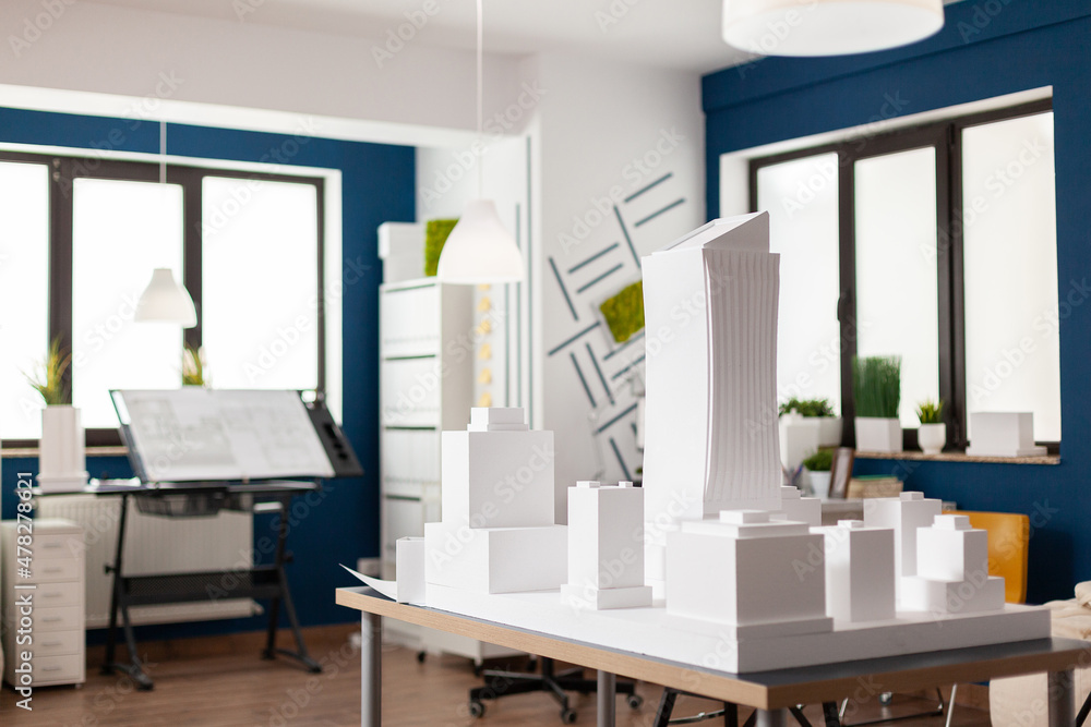 Table with white architectural scale foam model of building complex in ...