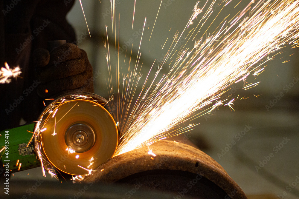 Spark grinder. Hot white sparks when cutting steel material. Industrial ...