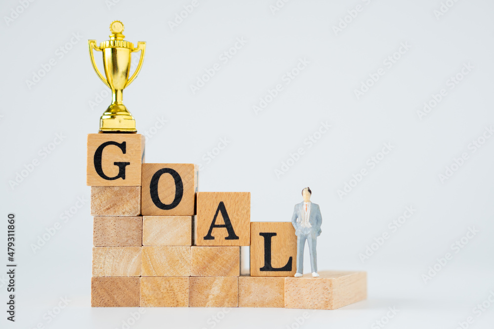 gold trophy and miniature businessman on word goal build be wooden ...