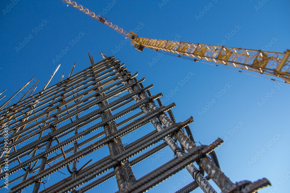 A reinforced steel rebar foundation work and tower crane against the ...