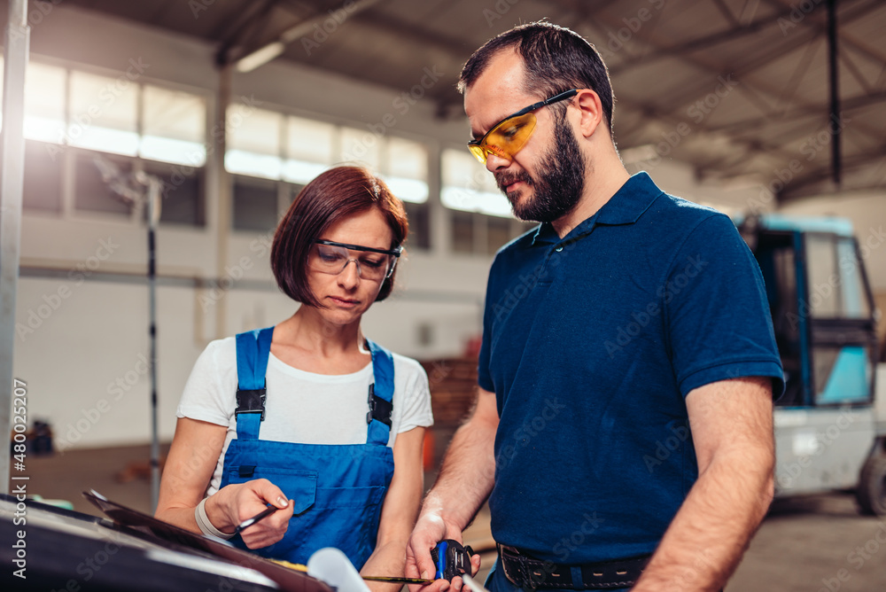 CNC Machine Operator and industrial engineer checking product drawing ...