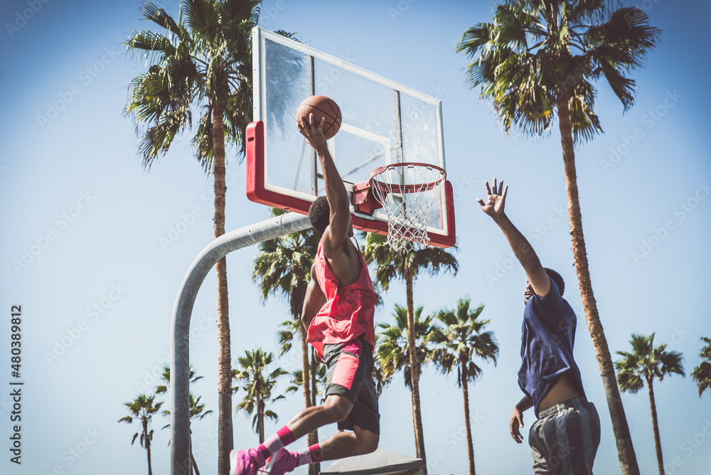 Young players playing basketball at the court in venice beach ...