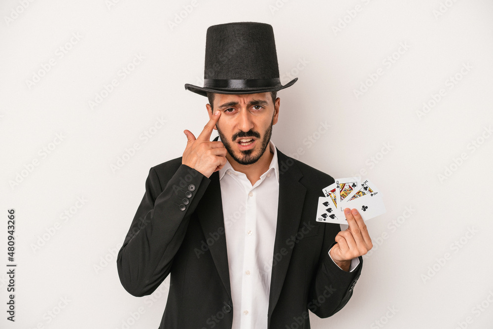 Young magician man holding a magic card isolated on white background ...