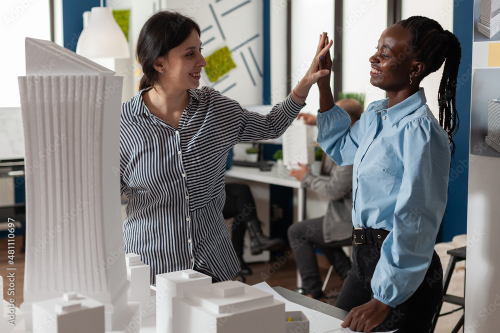 Foto de Stock Team of two women architects high fiving standing in ...