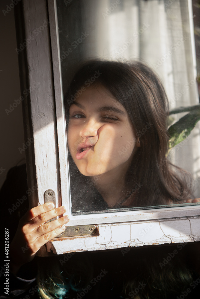 Through glass of ethnic girl pressing face against window Stock Photo ...