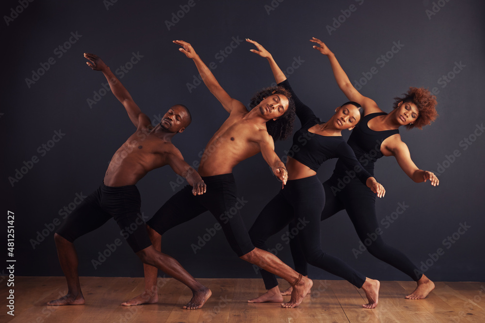 Perfectly synchronised. A group of dancers performing a dramatic pose ...