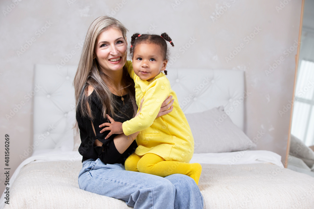 Multi-ethnic mom and daughter. Cheerful mother hugs her daughter of ...