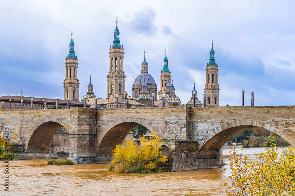 Medieval stone bridge with arches on the backdrop of the towers of ...