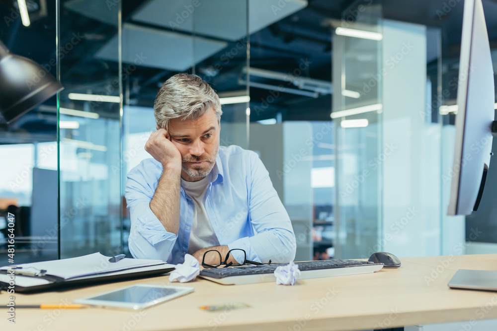sad gray-haired architect man working in modern office at computer ...