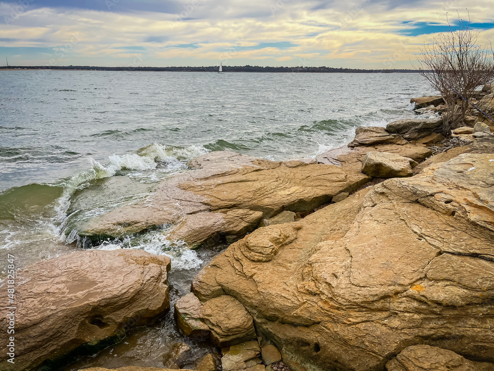 High waves over sandstone cliff along rocky shoreline and dropoffs at ...