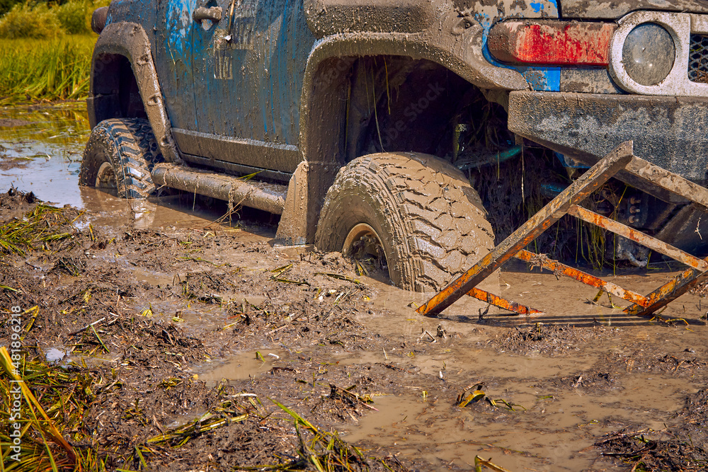 Blue 4x4 or 4WD car with wheels in mud on the off-road. An off-road car ...