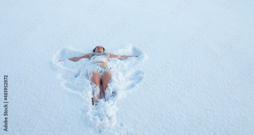 woman swims in a swimsuit in a snowy snowdrift. Tempering concept ...