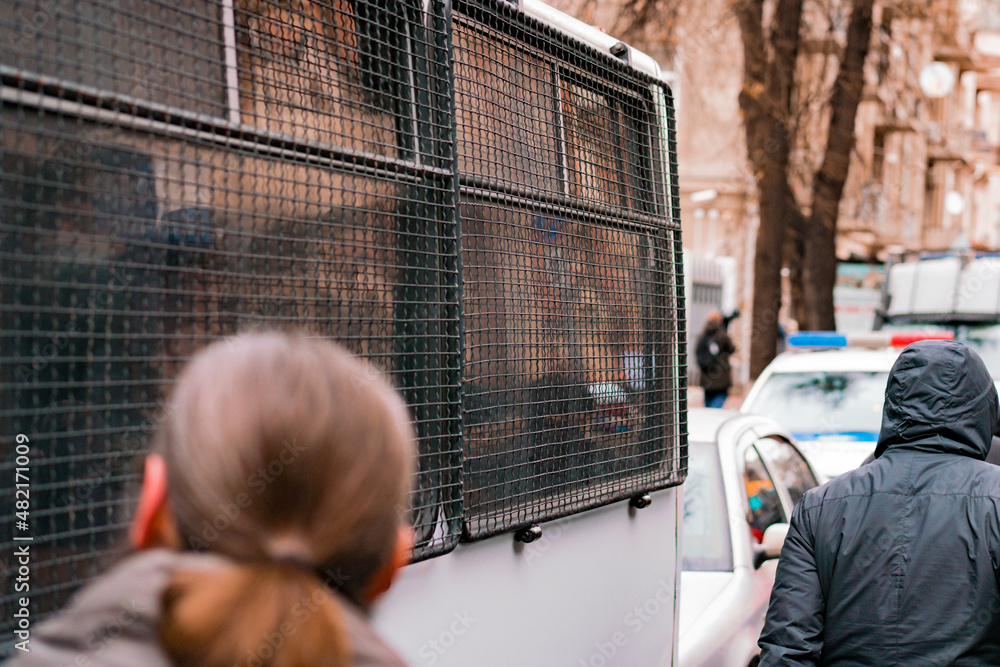 People on the street going through armoured bus with steel grids on the ...