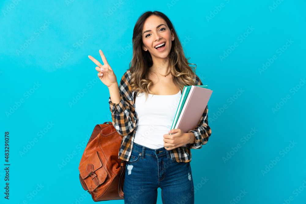 Young student woman isolated on blue background smiling and showing ...