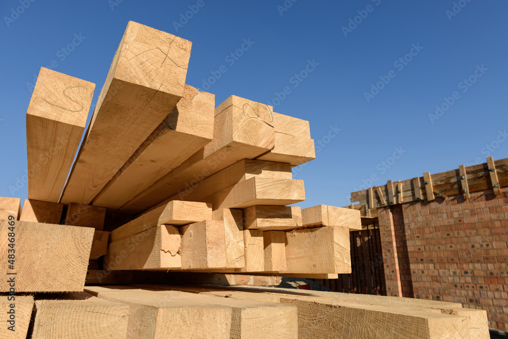 Wooden building materials. Stacked boards at a construction site ...