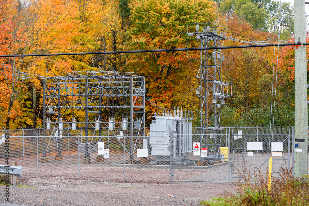 Fenced electrical substation with colourful autumn trees in background ...