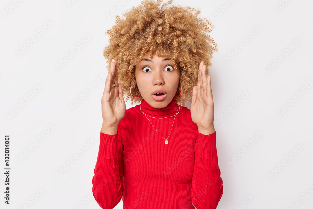Omg how big it is. Amazed curly haired woman raises palms and shows ...