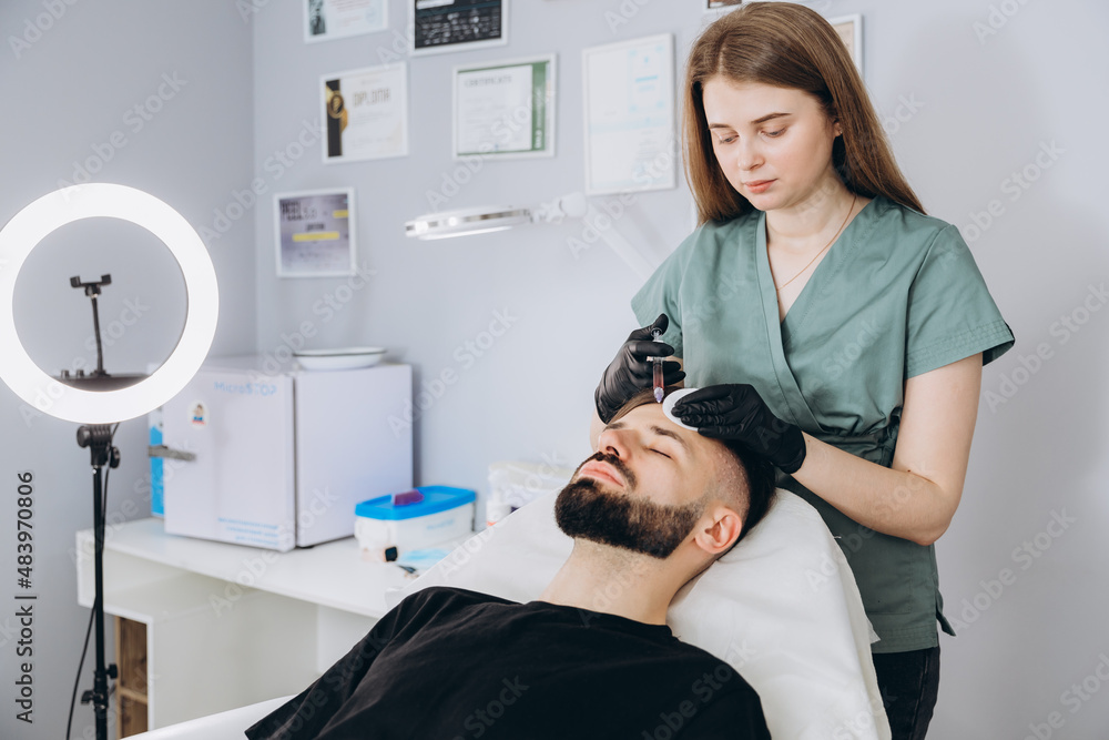 Mesotherapy for man hair. Attractive man receiving injections in his ...