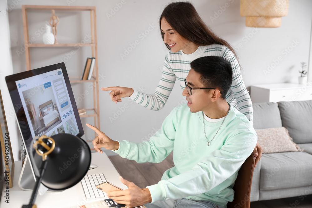 ภาพถ่าย Stock Young man and his wife pointing at computer screen with ...