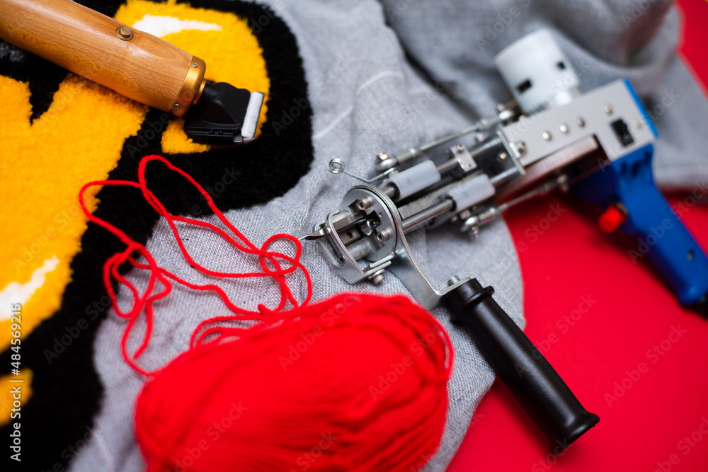 Fotografie The tufting gun lies on a gray burlap, ready to work with ...