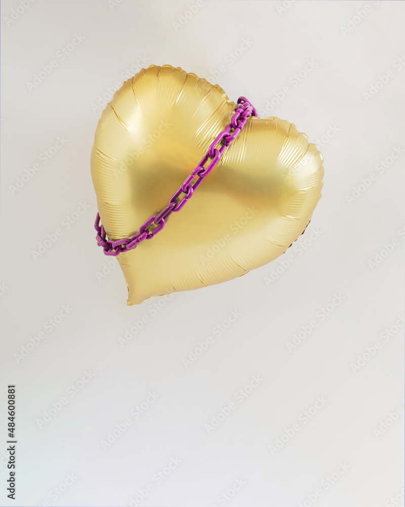 Heart balloon gold in the air with violet purple chains around it ...