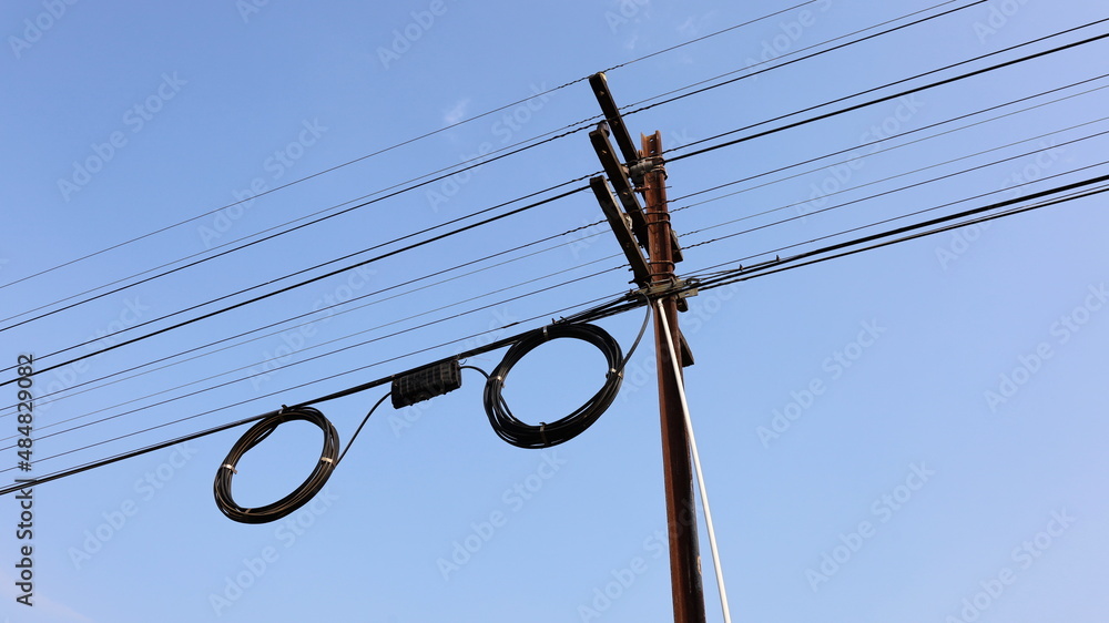 Black boxes and cable reels on poles. Internet box or splitter box with ...