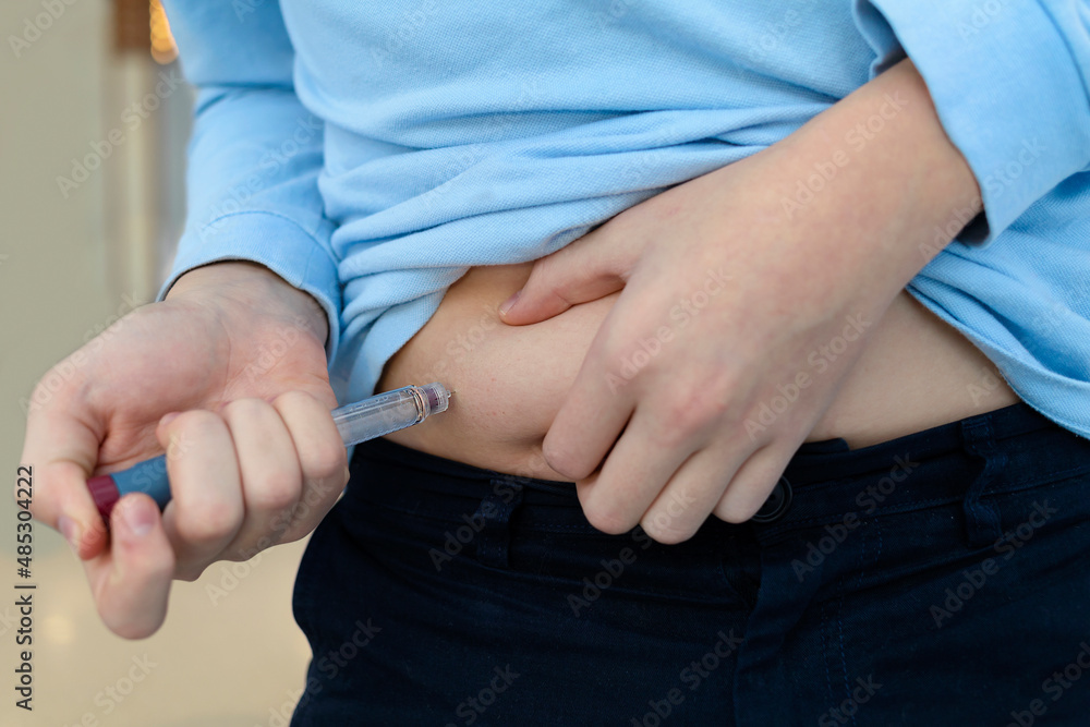 child injecting himself in his stomach. boy teenager patient hand ...