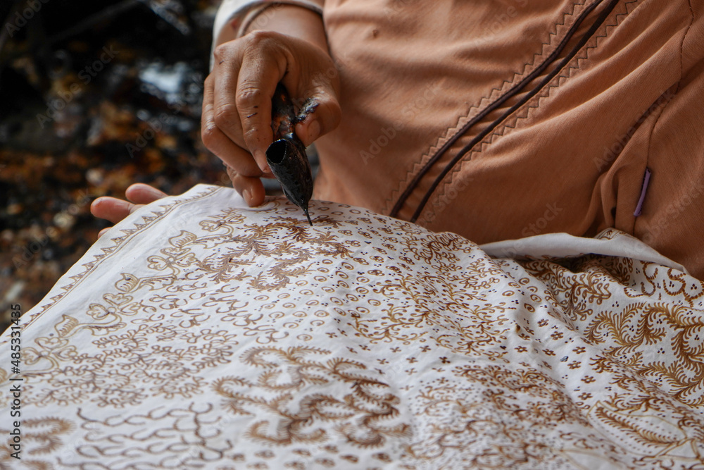 The technique of making batik by writing using a canting tool. Canting ...