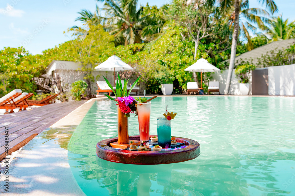 served floating tray in swimming pool with drinks and snacks on ...