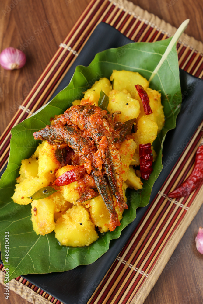 tapioca and spicy hot Kerala fish curry Indian food on banana leaf ...