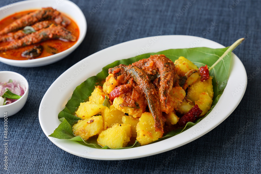 tapioca and spicy hot Kerala fish curry Indian food on banana leaf ...
