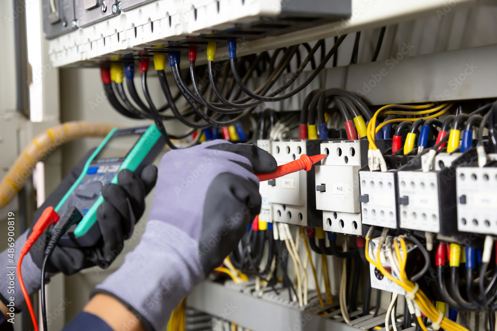 Electrician engineer tests electrical installations and wires on relay ...