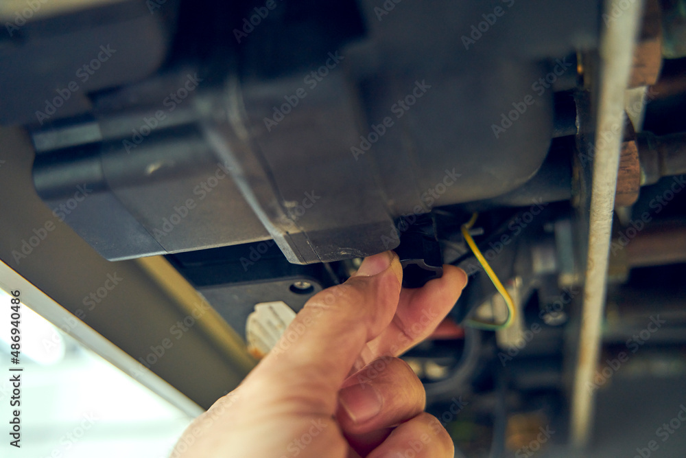 detail of a hand adjusting the dial that controls the water pressure ...