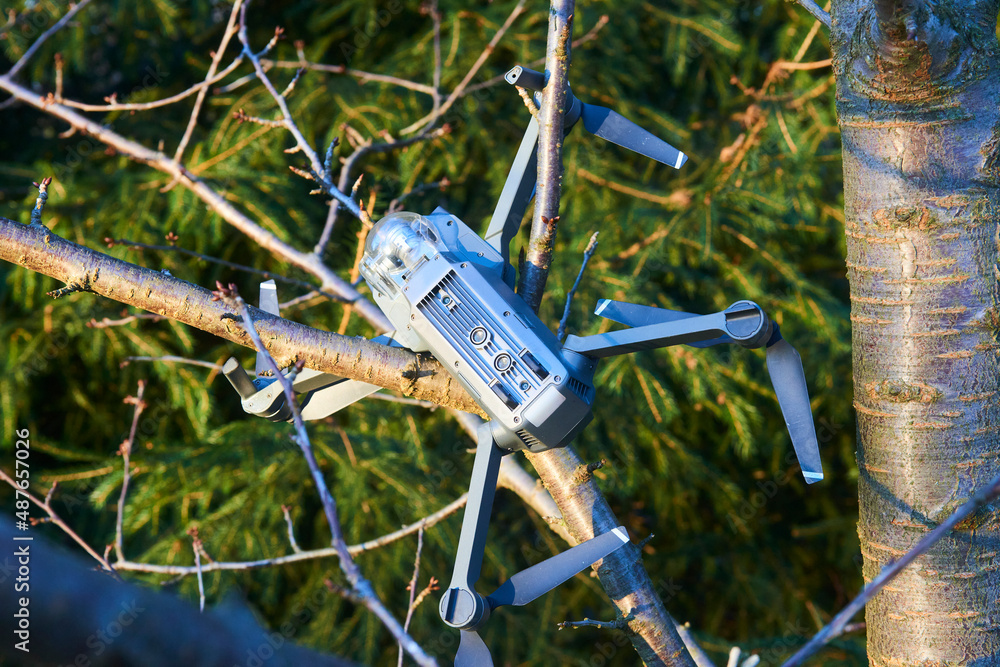 Drone quadcopter accident scene. UAV Quadrocopter crashed on tree in ...