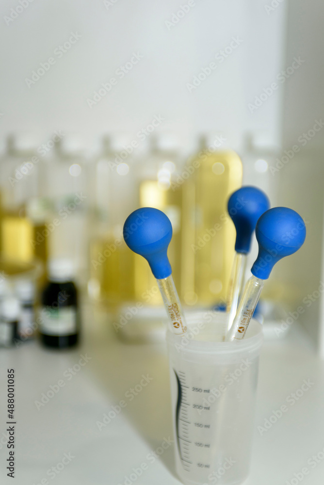 Laboratory instruments close-up. Measuring pipettes and a beaker on a ...