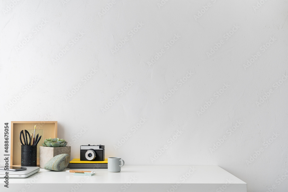 Table at home office against white wall. Stylish minimalist workspace ...