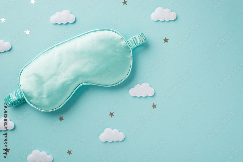 Top view photo of the big silk blue sleep mask and a confetti in shape ...