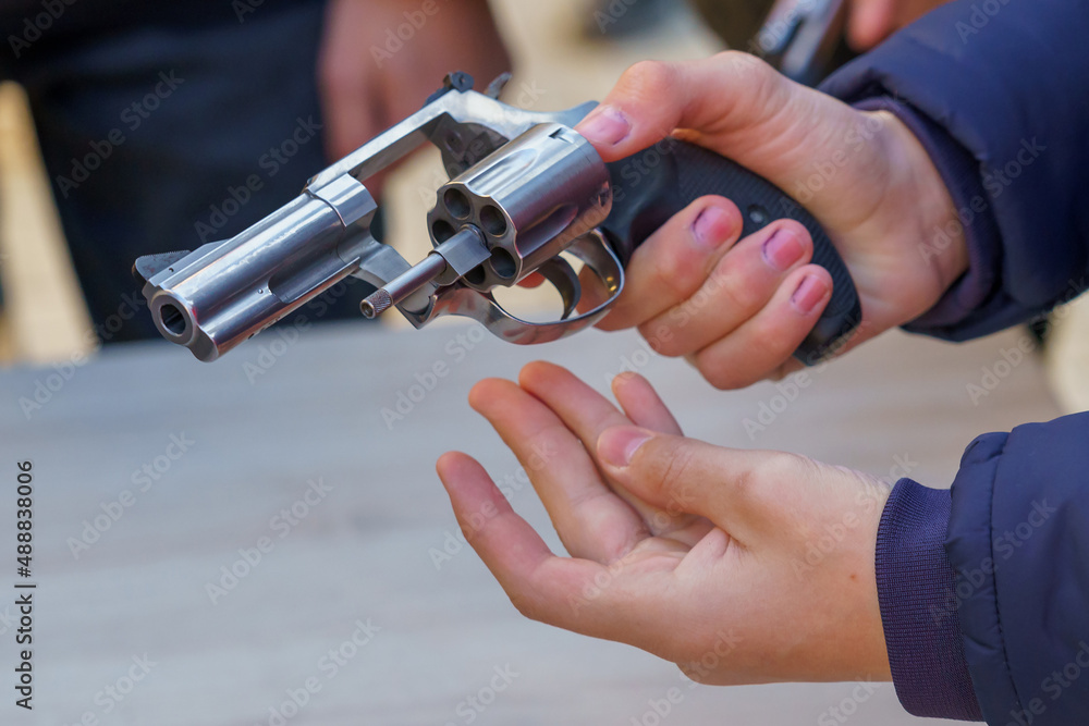 Revolver in the hands of a young man, selective focus. Reloading ...