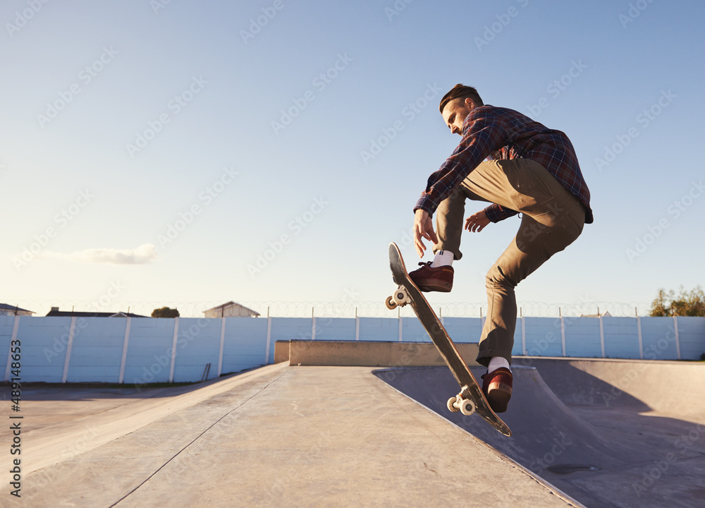 A rad day at the skate park. A young man doing tricks on his skateboard ...